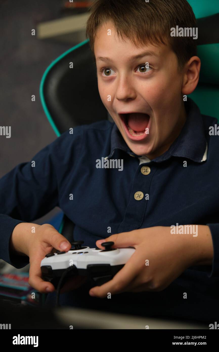 the boy is playing a video game console Stock Photo - Alamy