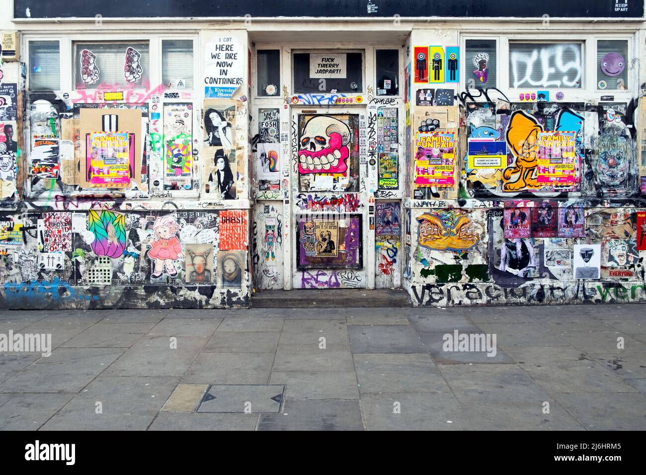 Graffiti art and text covering the shopfront of a closed shop in Brick ...