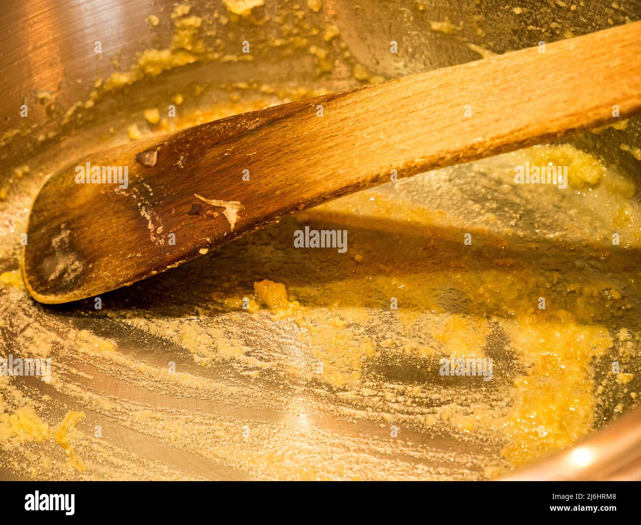Dirty stainless steel pan with wooden spoon Stock Photo - Alamy