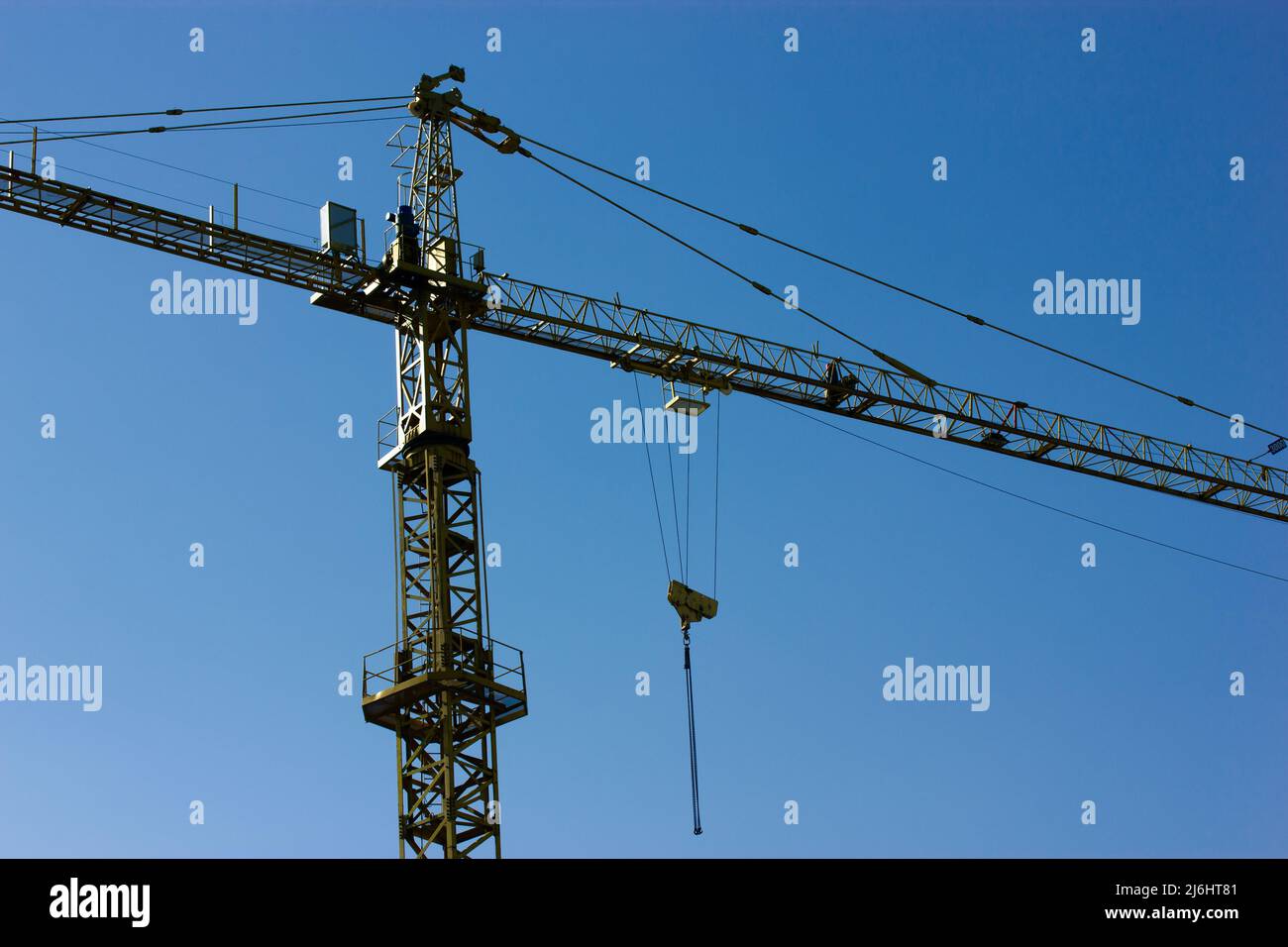 Construction crane against blue sky view from below. Construction site ...