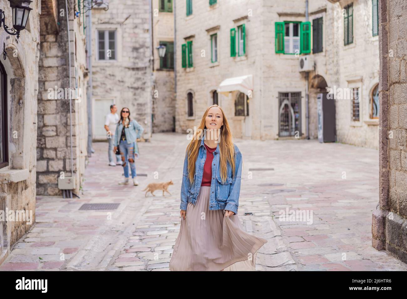 Woman tourist enjoying Colorful street in Old town of Kotor on a sunny ...