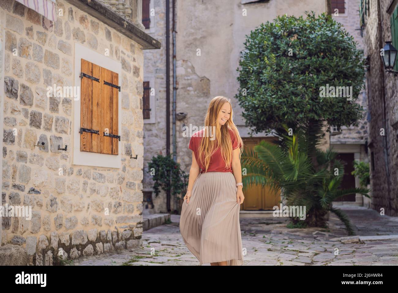 Woman tourist enjoying Colorful street in Old town of Kotor on a sunny ...