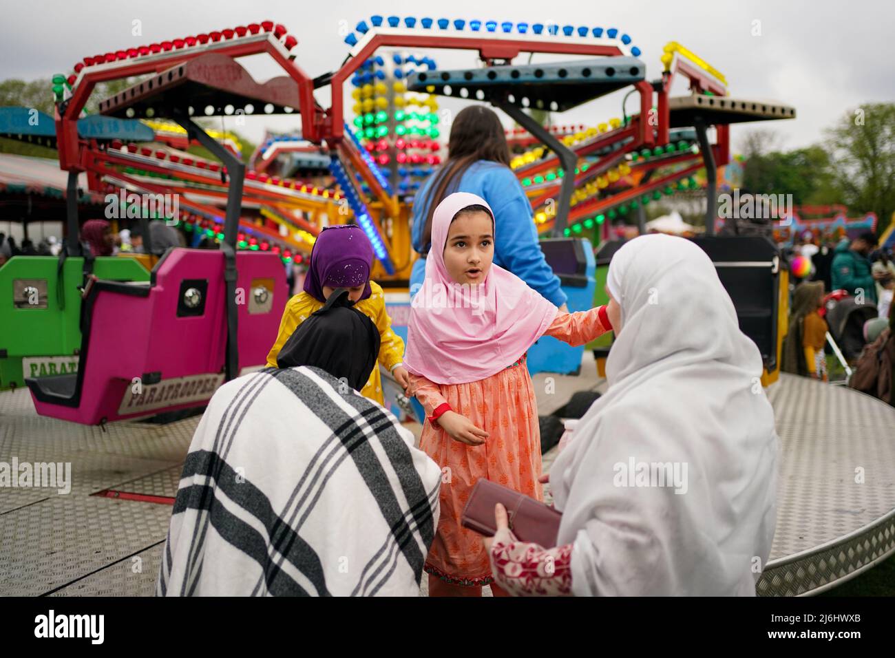 People enjoy theme park rides at a funfair at Small Heath Park in ...
