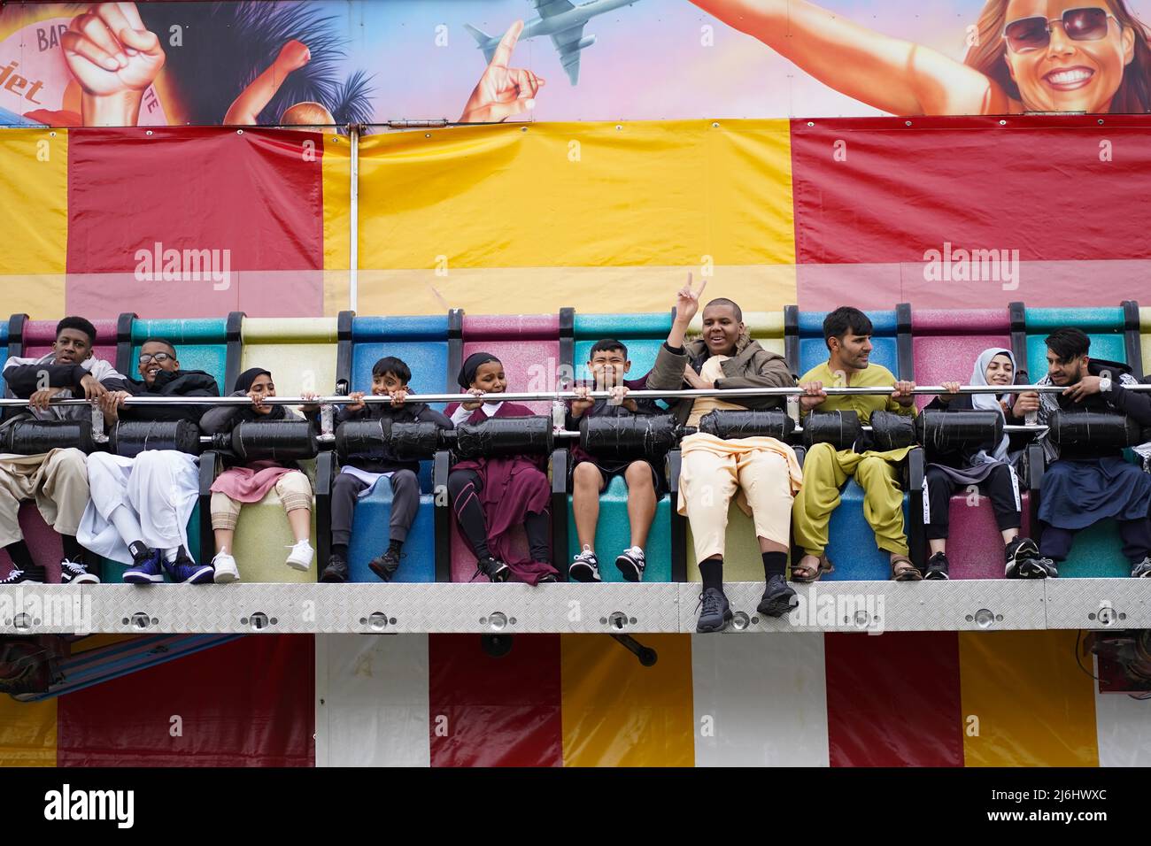 People enjoy theme park rides at a funfair at Small Heath Park in ...