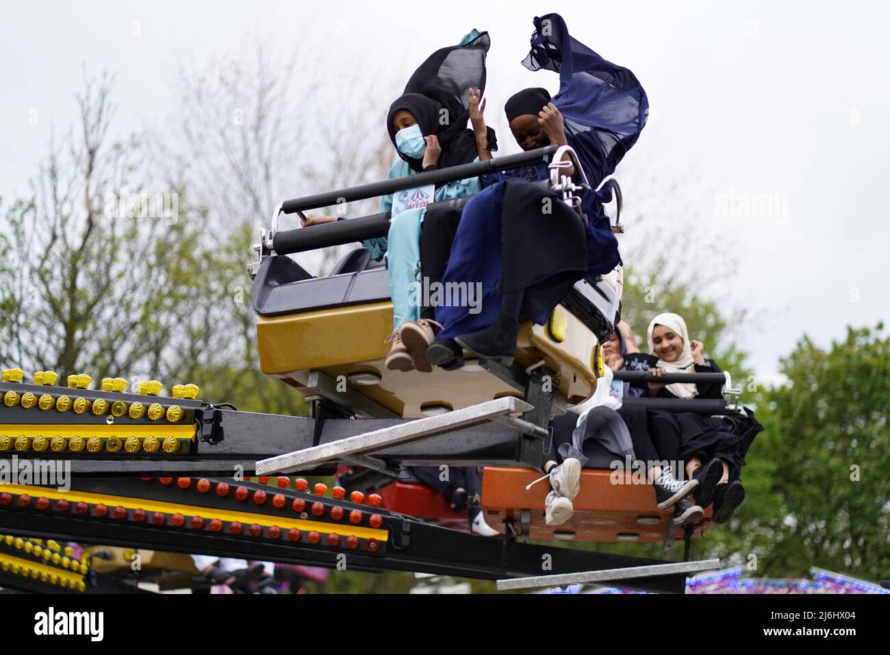 People enjoy theme park rides at a funfair at Small Heath Park in ...
