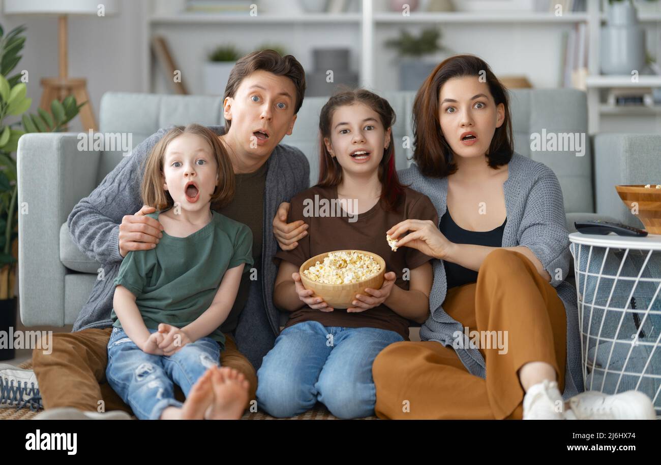 Family watching projector, TV, movies with popcorn in the evening at ...