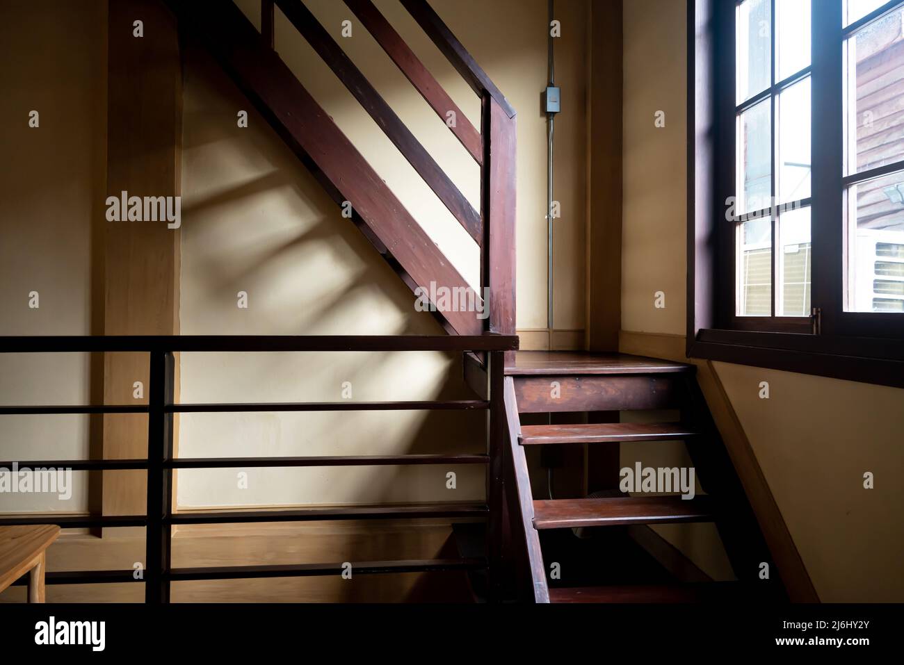 Old wooden staircase by the window. Interior shadow from the natural ...