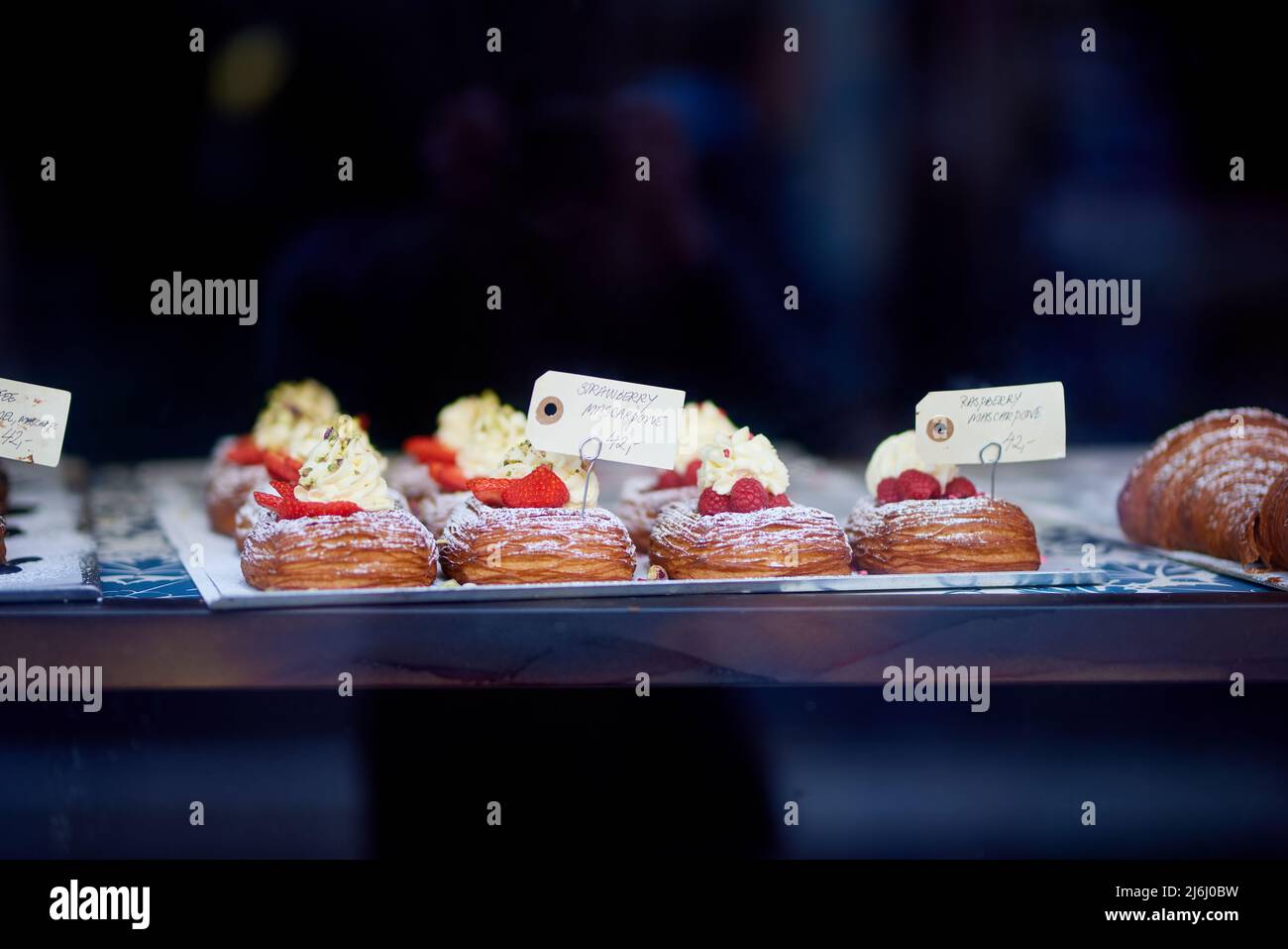 Strawberry and raspberry mascarpone pastries in bakery shop window ...