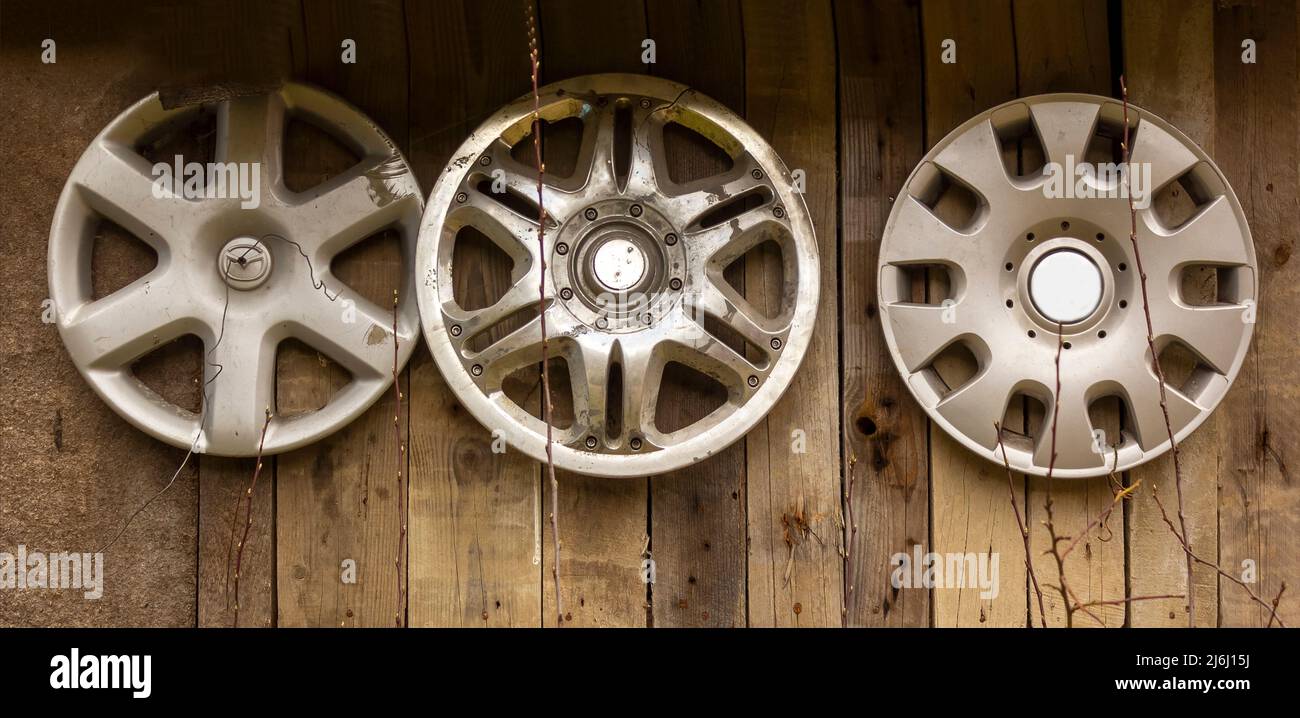 Old wheel rims from different cars on the wall, like a design on the ...