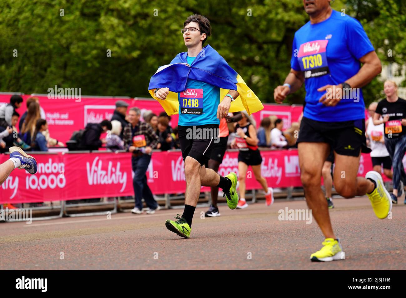 A runner wears a Ukrainian flag as they compete in the Run For Ukraine ...