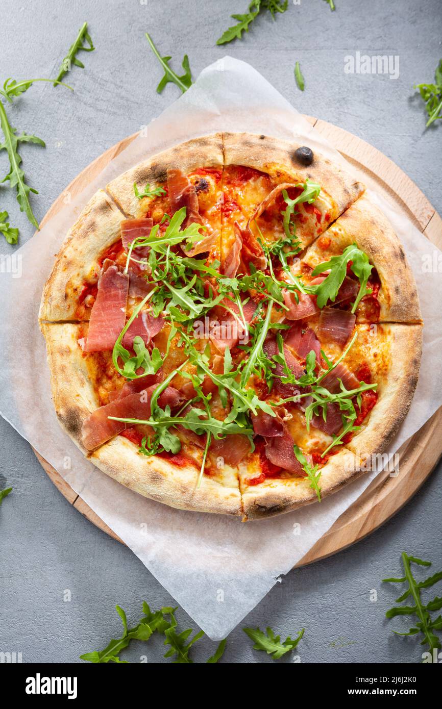 Top view sliced pizza with meat jamon and arugula Stock Photo - Alamy