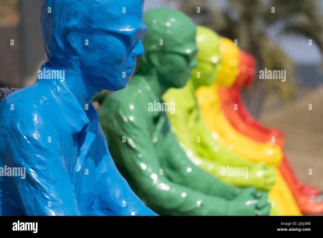 7 colorful statues of men look towards the ocean and the 7 Moai statues ...