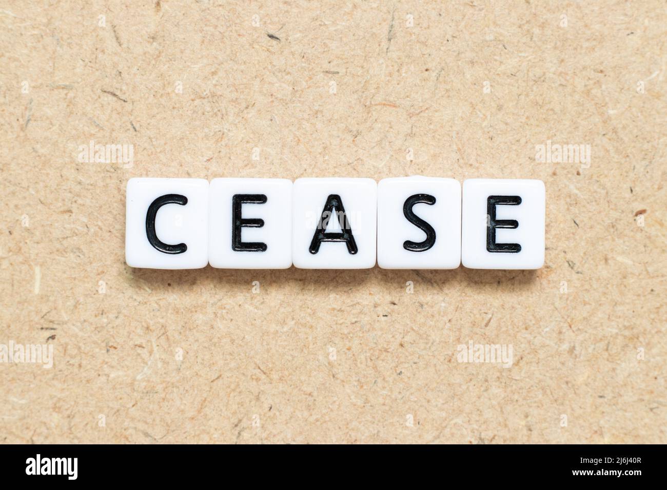 White tile alphabet letter with word cease on wood background Stock ...