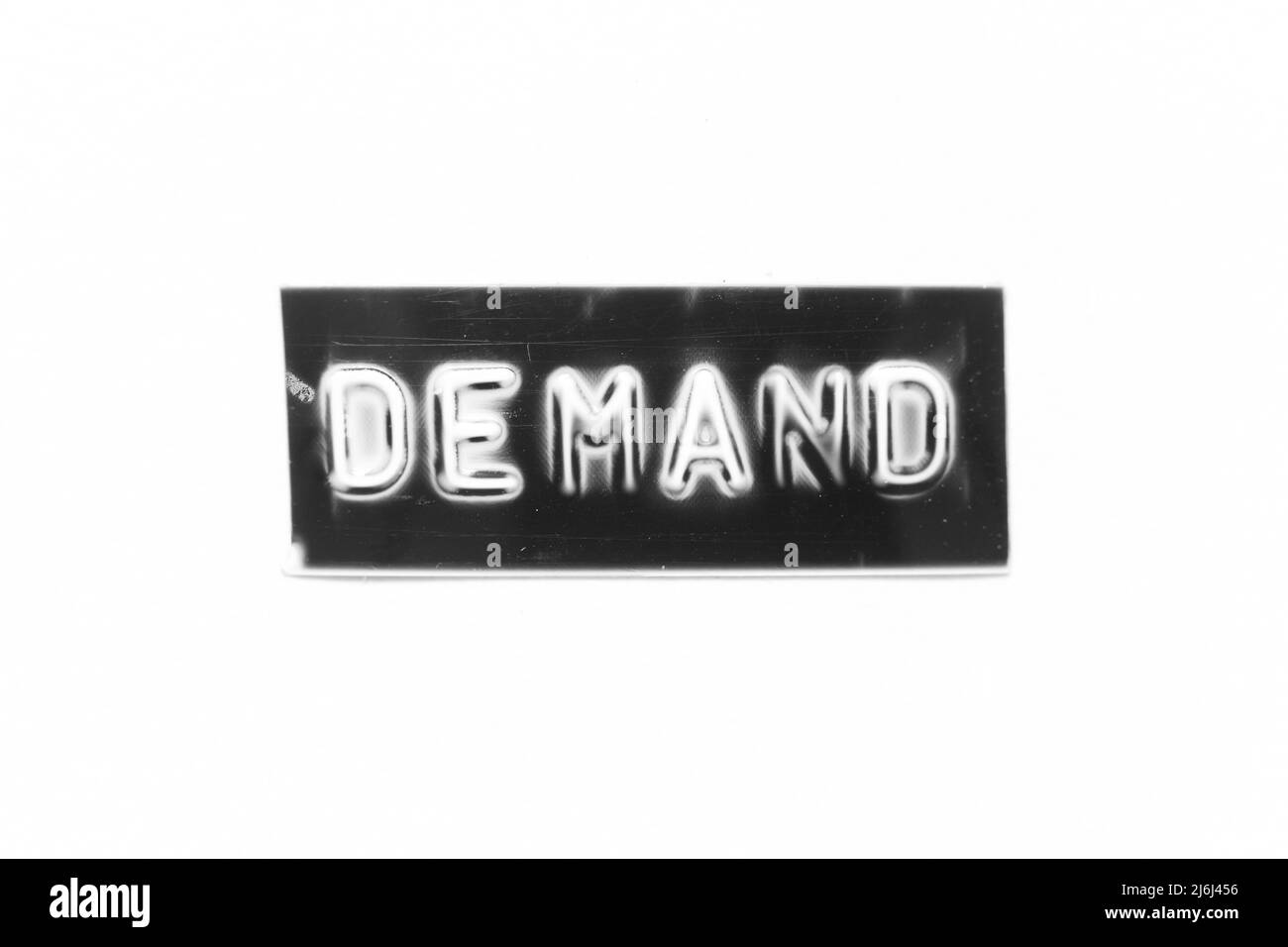 Black color banner that have embossed letter with word demand on white paper background Stock ...