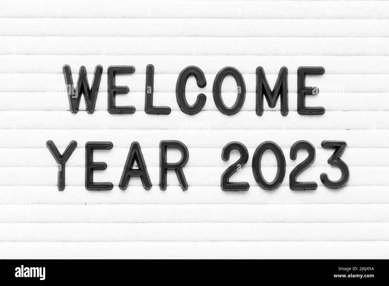 Black color letter in word welcome year 2023 on white felt board ...