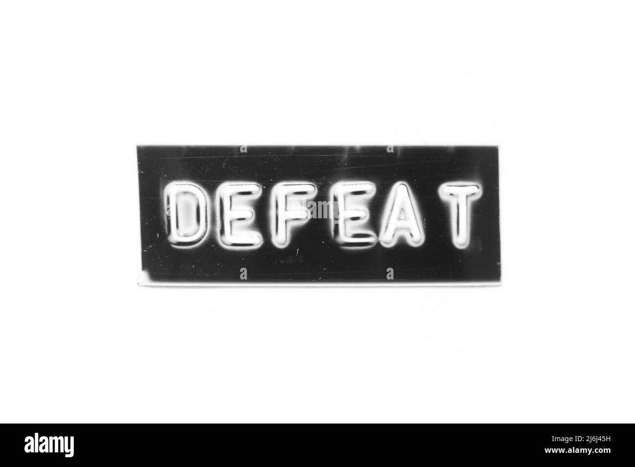 Black color banner that have embossed letter with word defeat on white ...