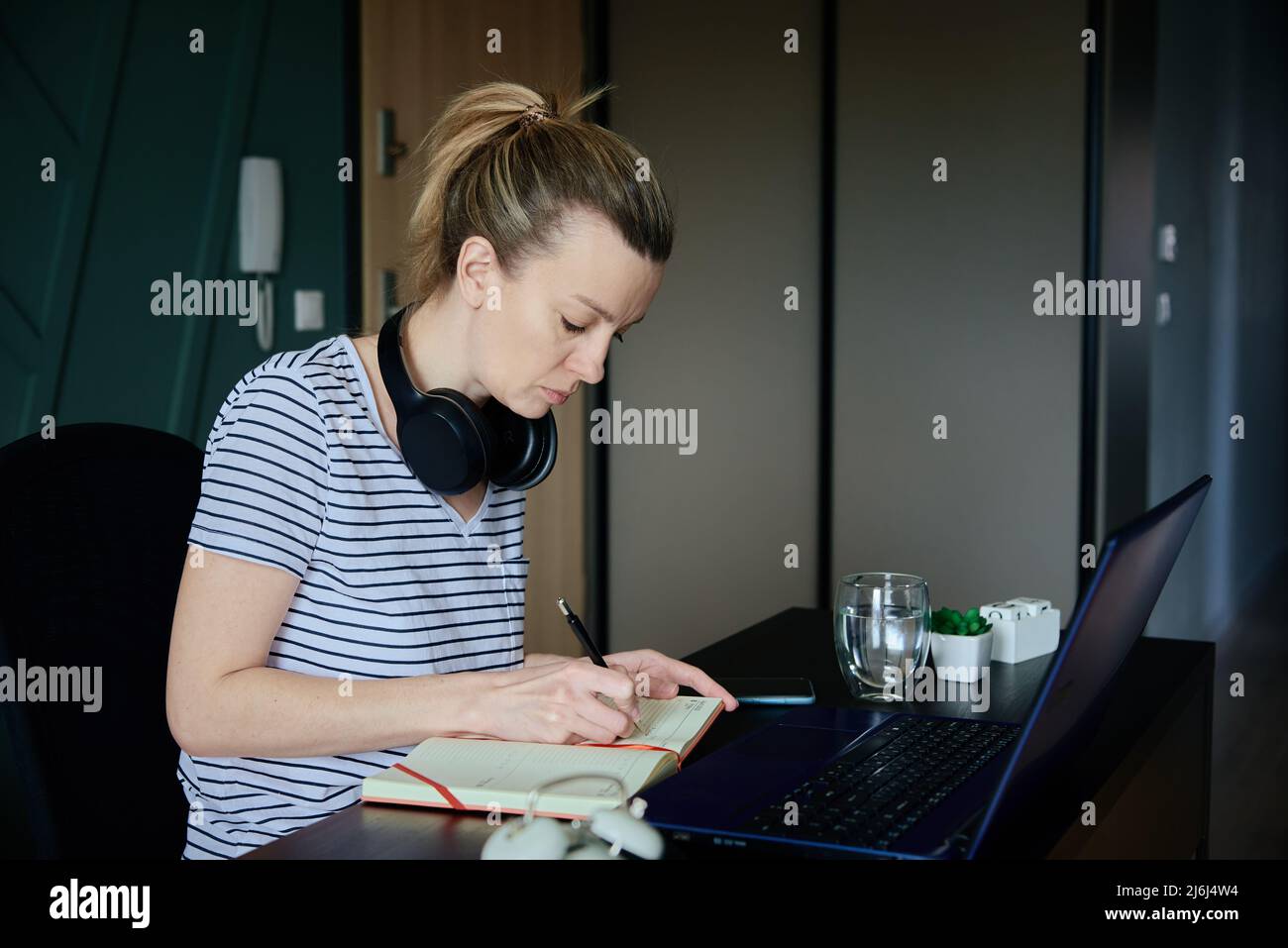 Woman working remotely at home office with laptop Stock Photo - Alamy