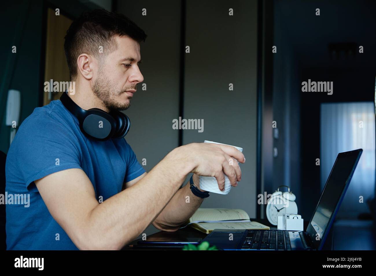 Man working remotely at home office with laptop Stock Photo - Alamy