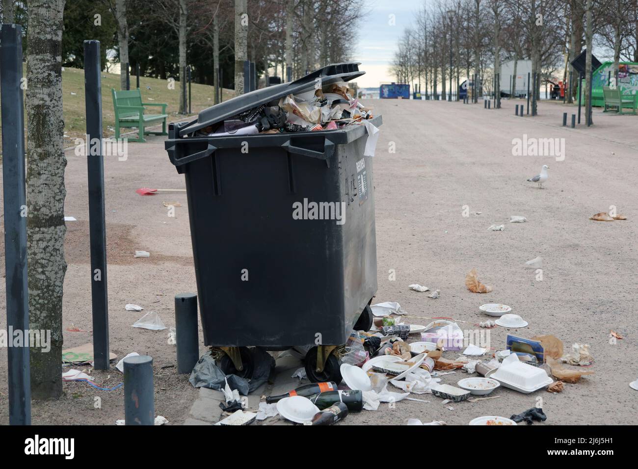 Overflowing waste bin in the park after May Day celebrations in ...
