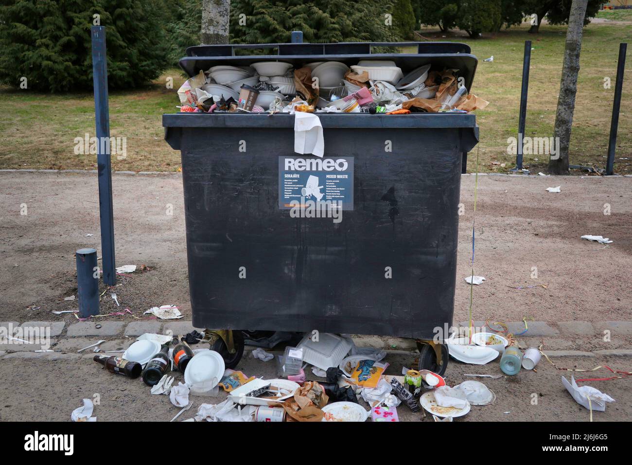 Overflowing waste bin in the park after May Day celebrations in ...