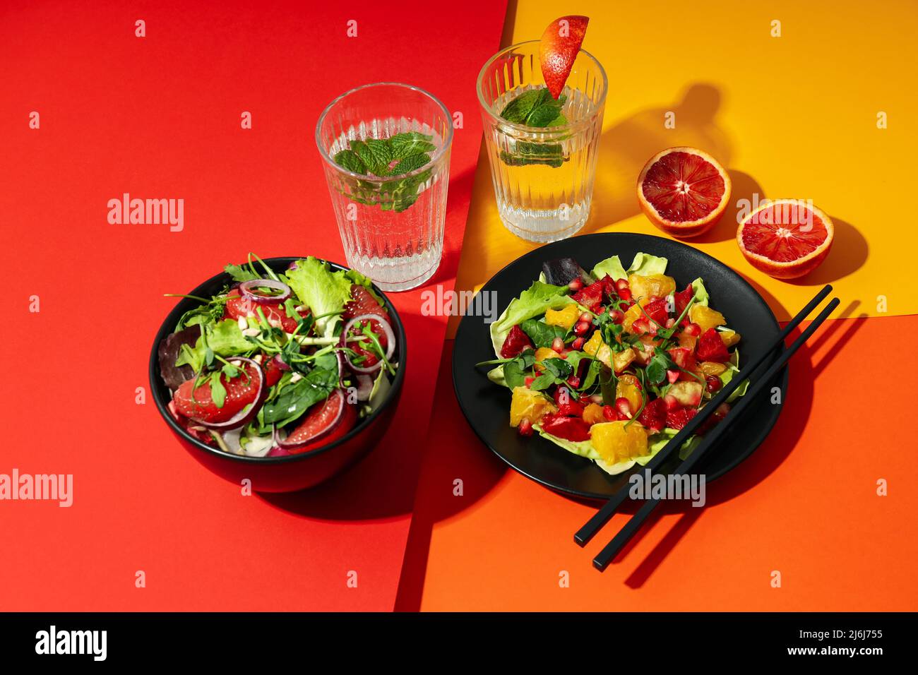 Concept of tasty food, salad with red orange on multicolor background ...
