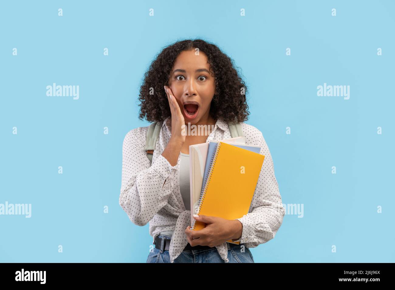 Shocked black female student with notebooks and backpack shouting ...