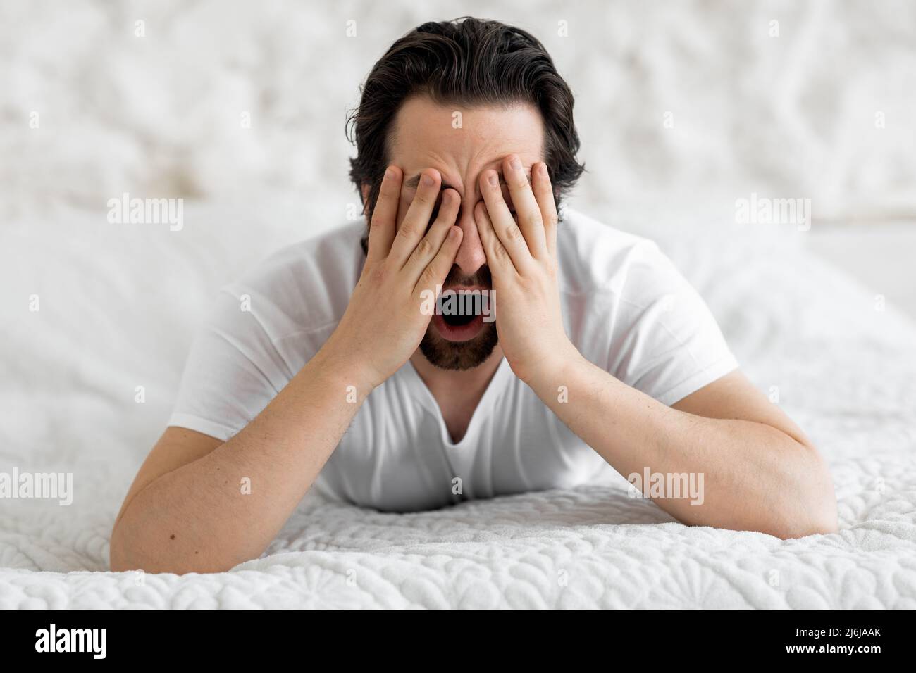 Closeup of bearded man laying in bed, yawning Stock Photo - Alamy