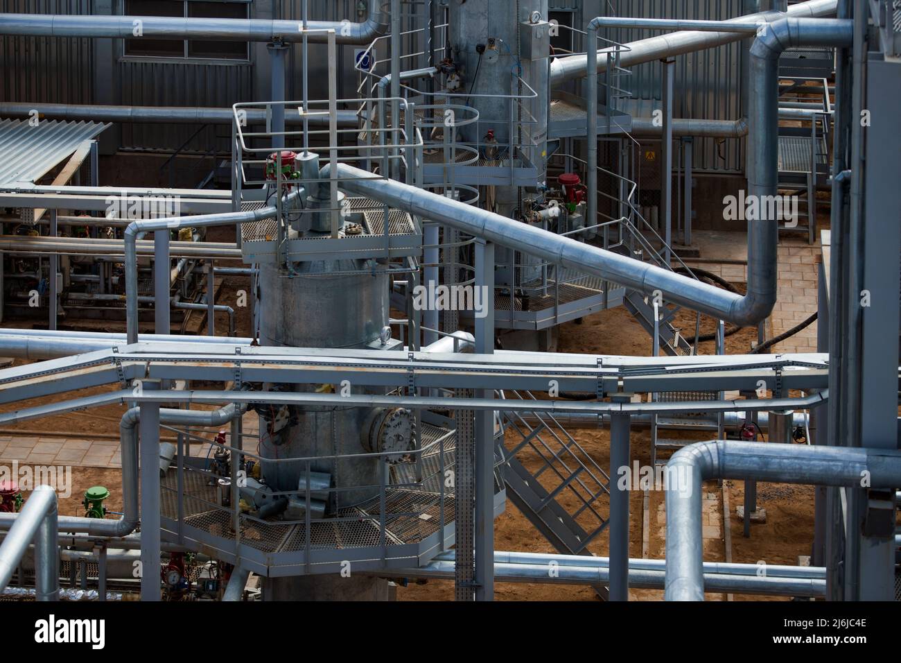 Grey metal pipes of distillation tower (refinery column). Oil refinery ...