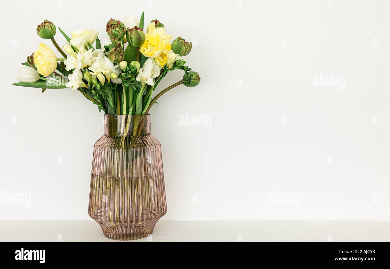 Glass vase with flowers in the interior of the room Stock Photo - Alamy