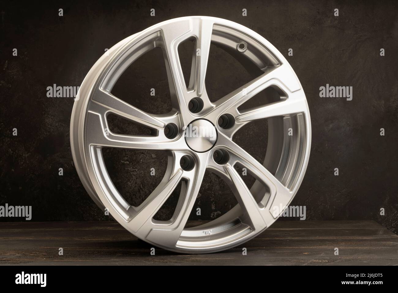 new grey alloy wheels on a dark textured black background. a wheel for ...