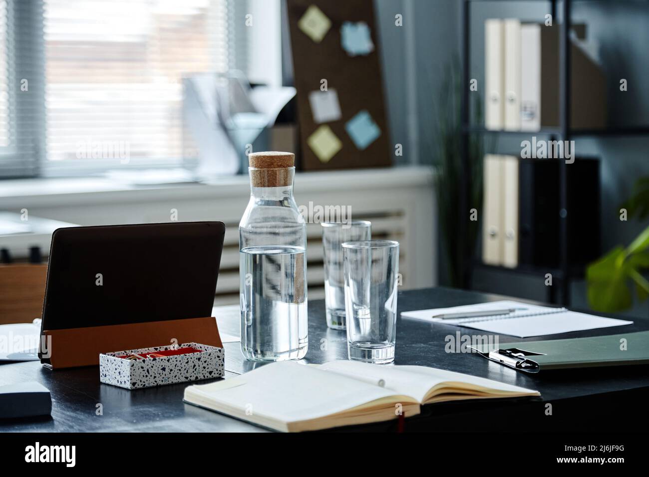 Close up of meeting table with computer and water bottle, copy space ...