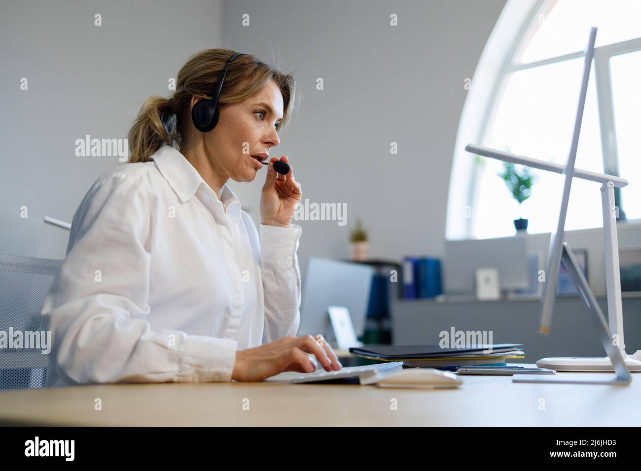 Beautiful female call center operator working on computer in office ...