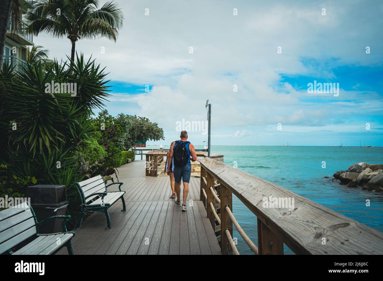 Man walks on dock next to the blue ocean water in Key West, Florida ...