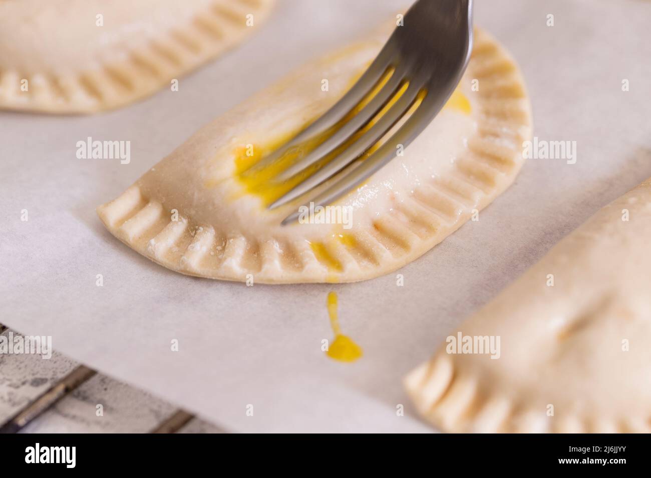 Close up of empanada, small spanish pies on baked paper. Cooking ...