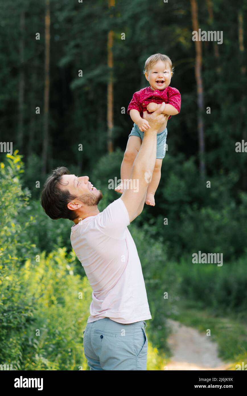 Happy dad having fun with his little son, holding him in his arms at ...