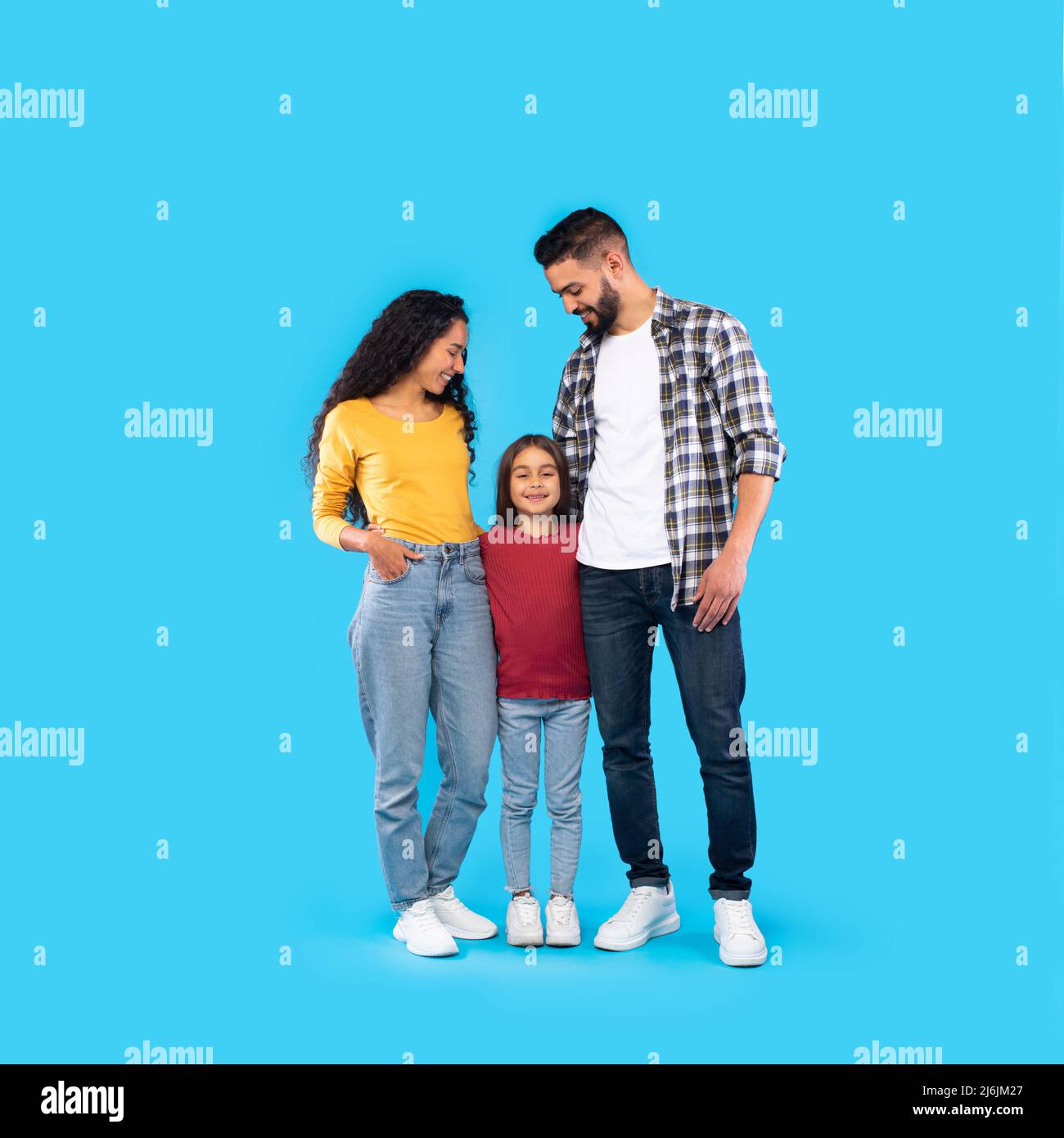 Young Middle Eastern Parents Hugging Their Lovely Daughter, Blue ...