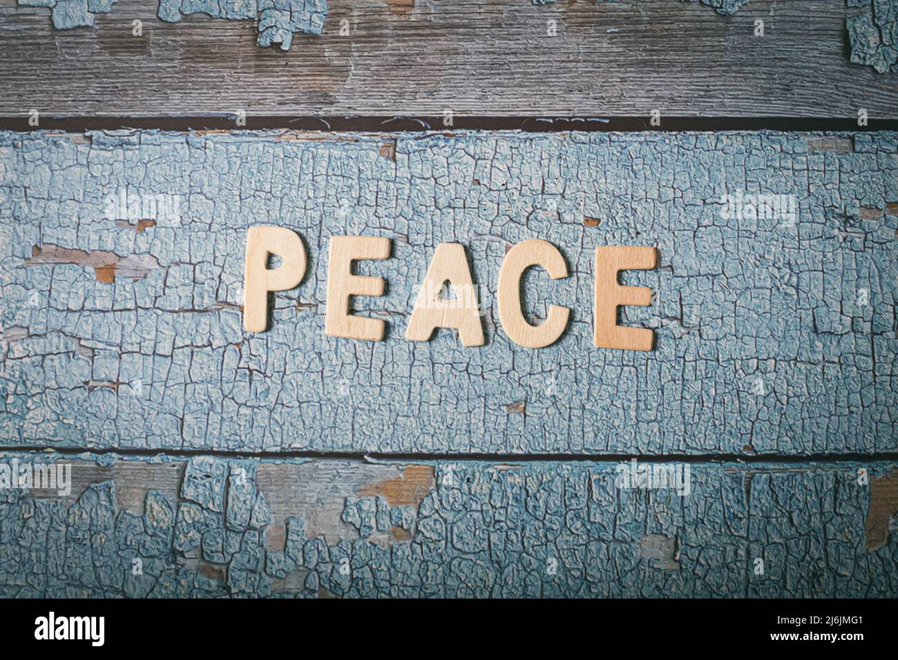 Peace text written with wooden words on a blue texture wooden board ...