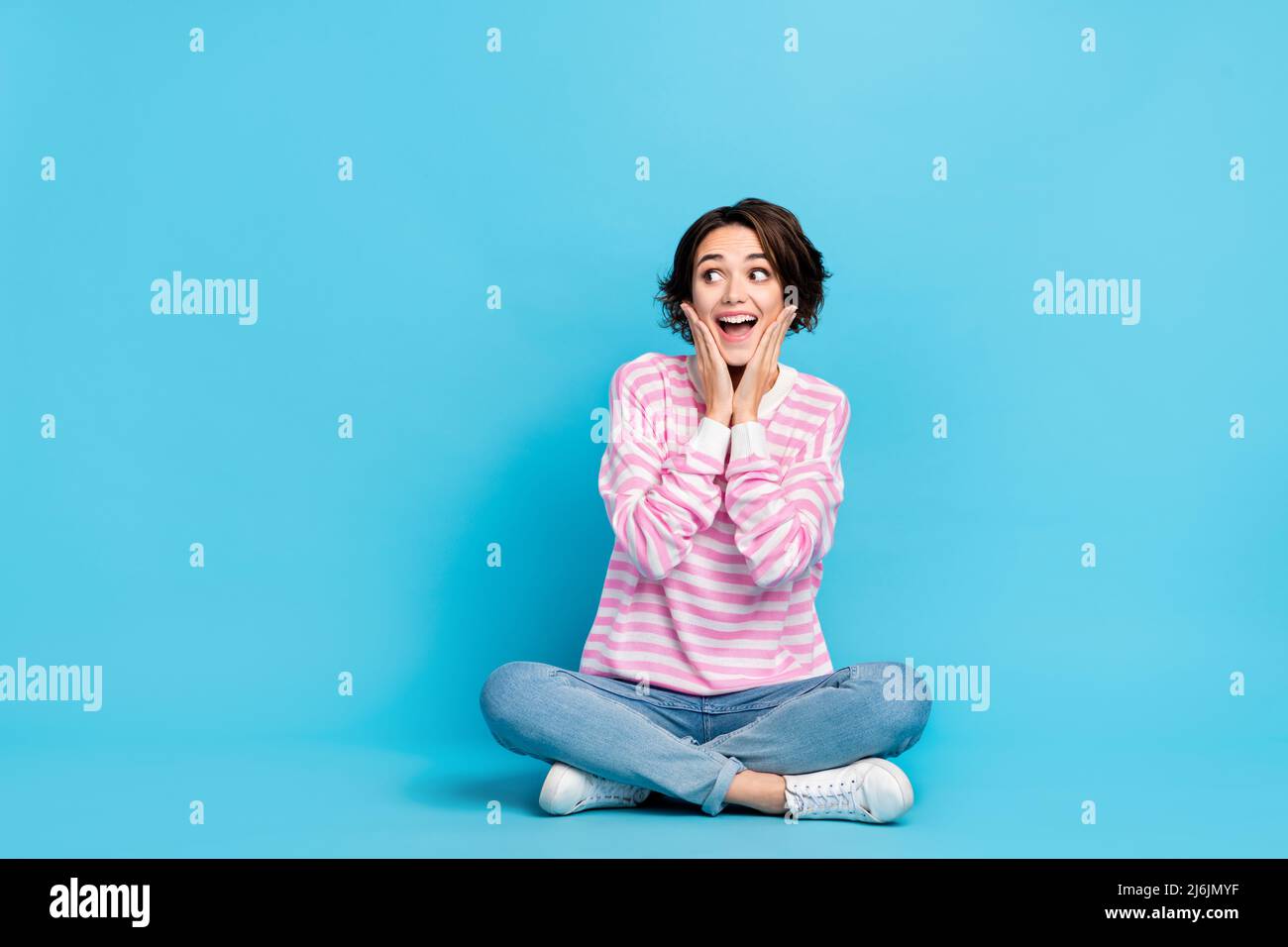 Portrait of impressed astonished girl sitting floor see huge bargain on ...
