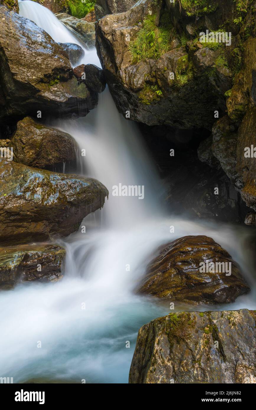 Between rocks falls a raging mountain stream of clear water ...