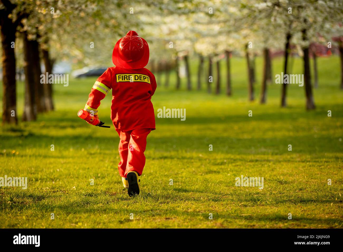 Little toddler child with fireman costume in park, pretending to be ...