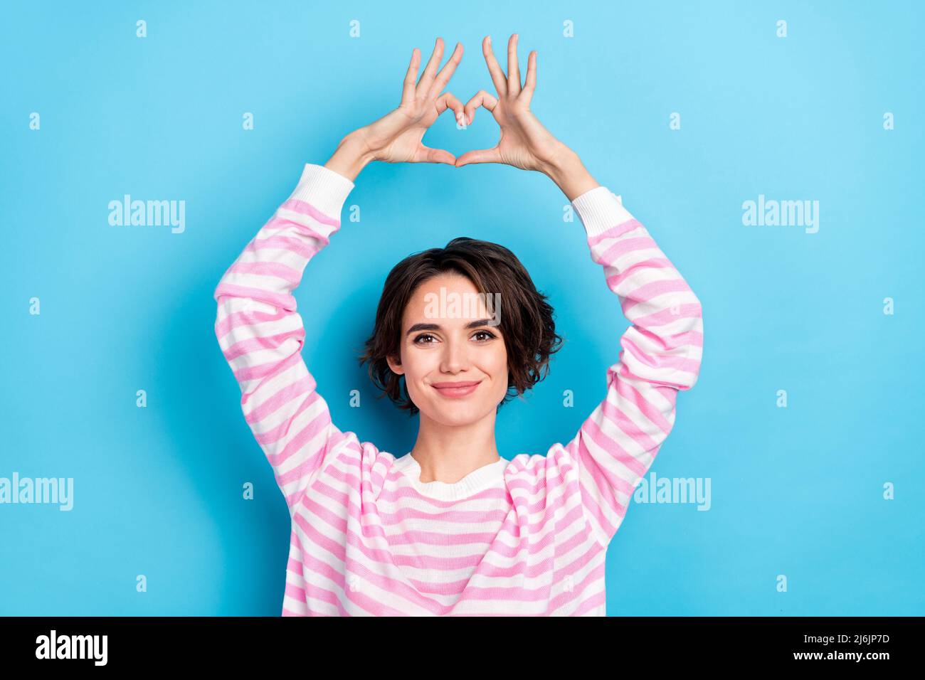 Photo of young lovely positive girl showing heart symbol above head ...