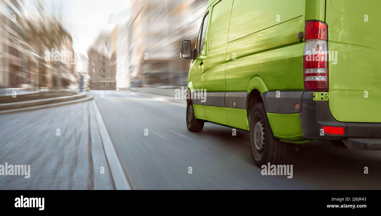 Green van driving through a city Stock Photo - Alamy