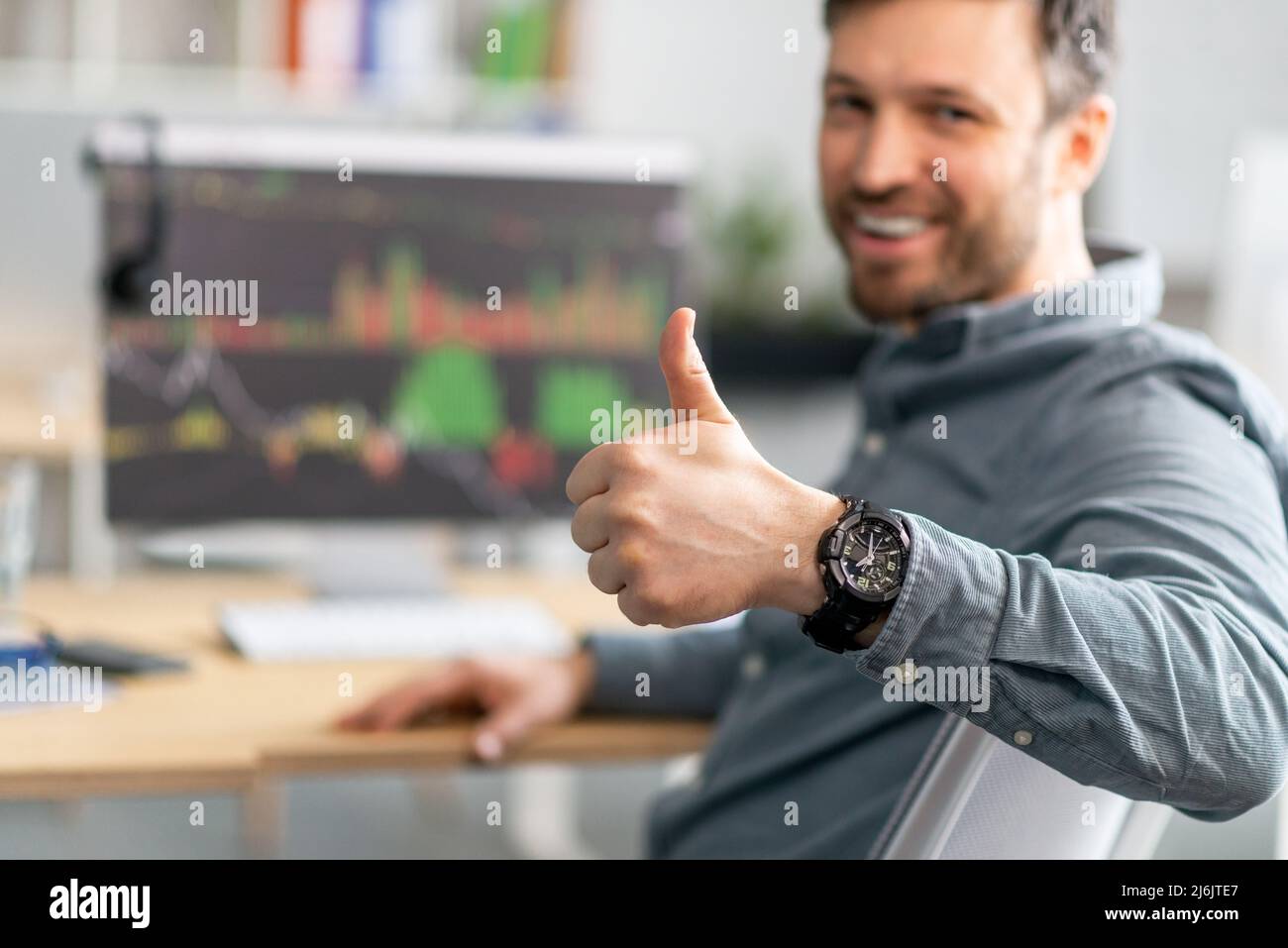 Positive mature businessman working on computer with graphs and charts ...