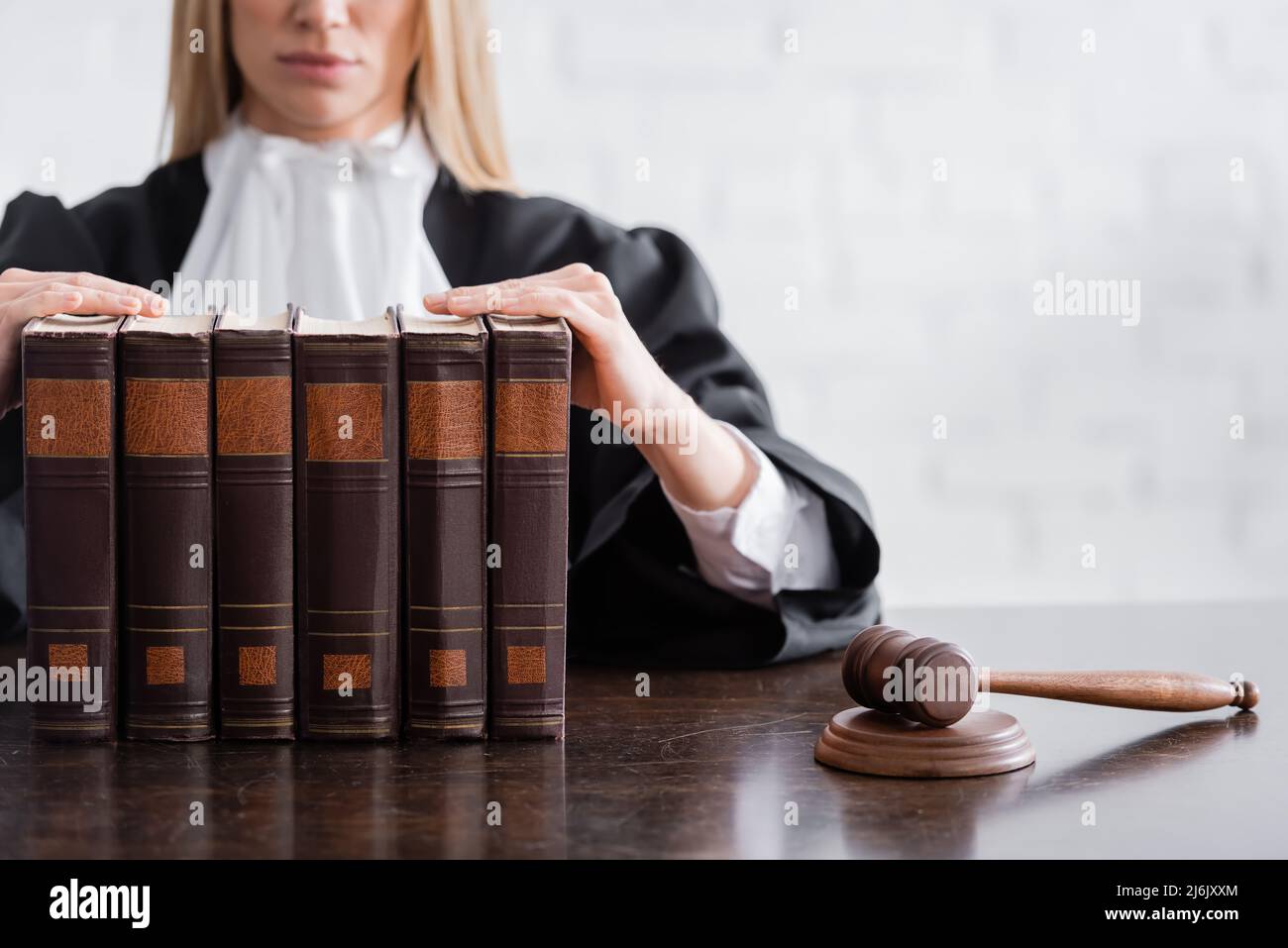 partial view of prosecutor sitting near collection of books and wooden ...
