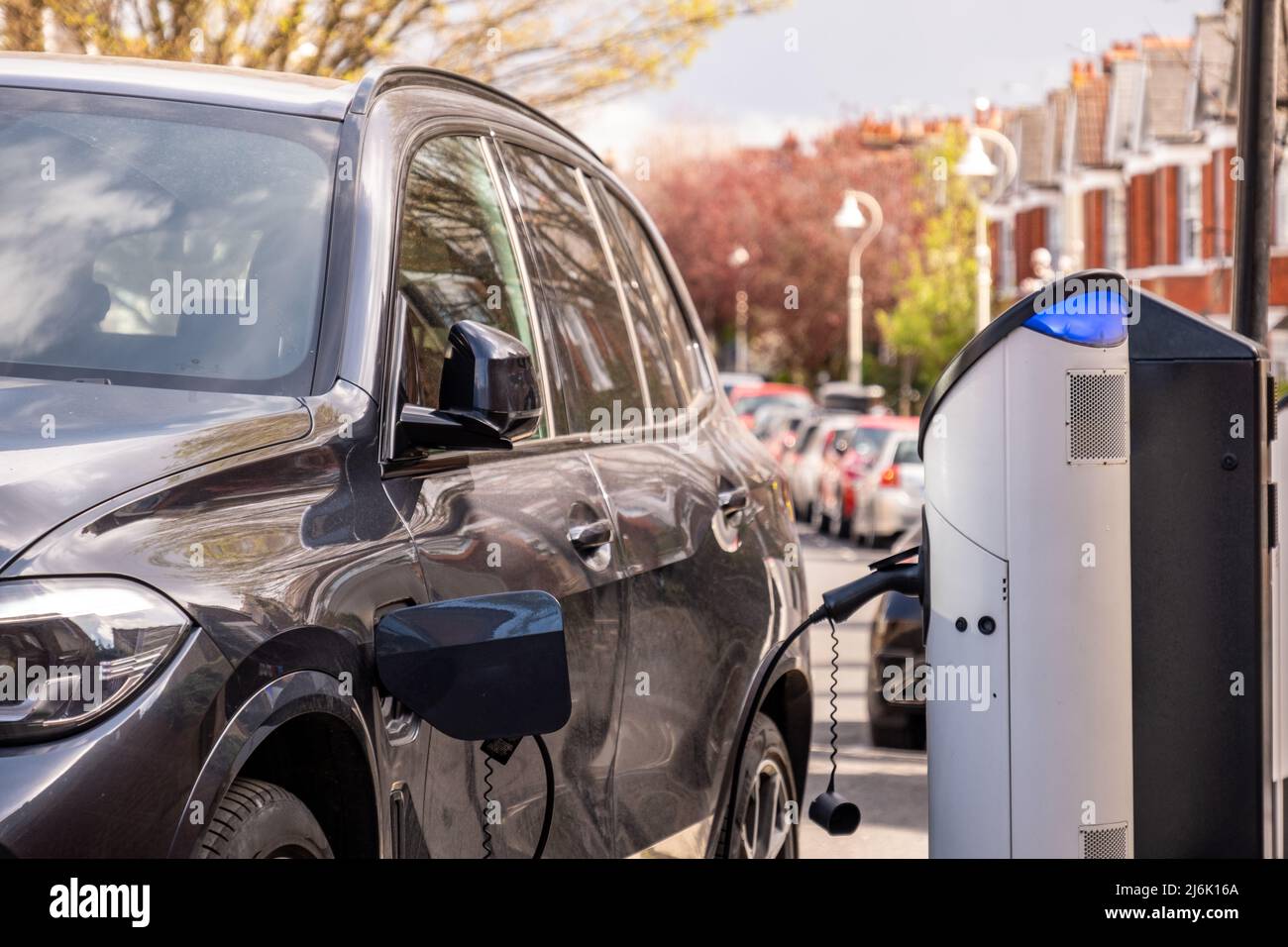 An electric car on-street charging on residential street Stock Photo ...