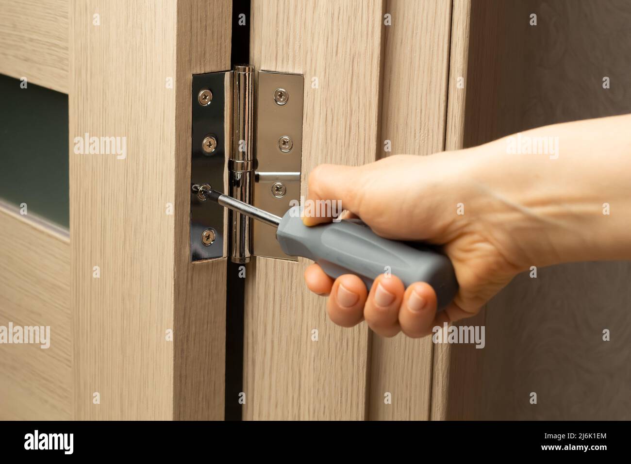 Carpenter installs a door hinge Stock Photo - Alamy