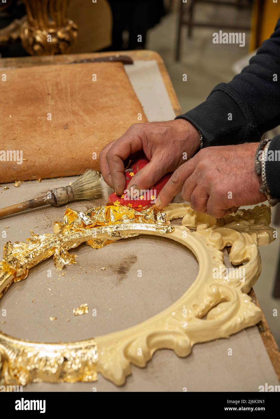 Application of gold leaf to a frame. Gilding process technique Stock ...