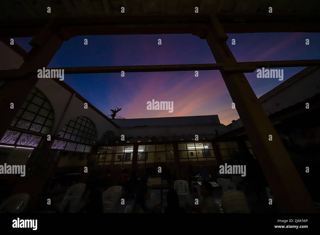 Purple and pink colored sky at dusk seen on the patio and roof of the ...