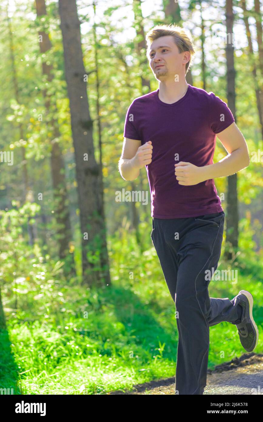 Running man jogging in city park at beautiful summer day. Sport fitness ...