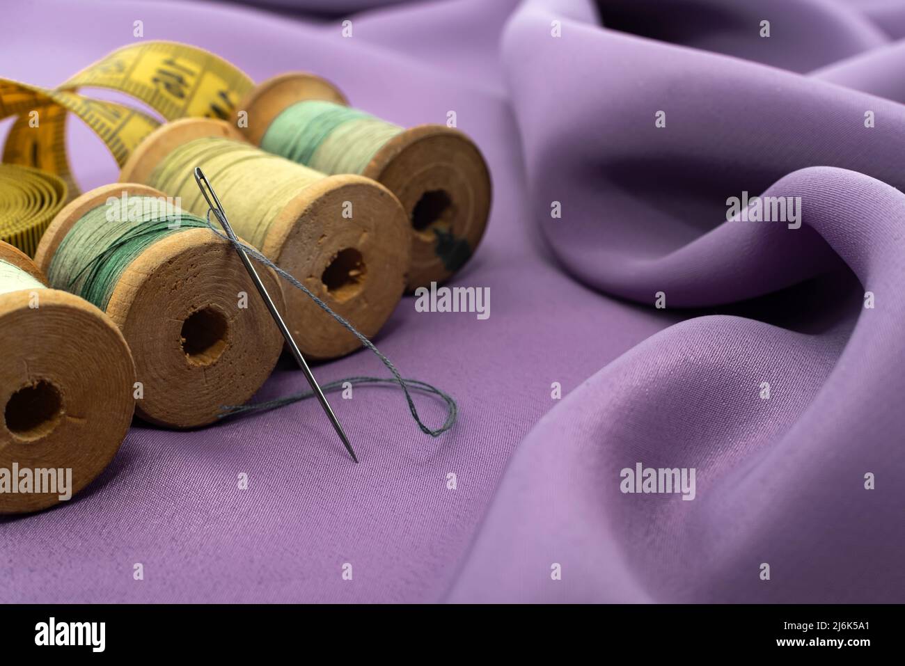 Vintage retro spool of thread on a black and white fabric background ...